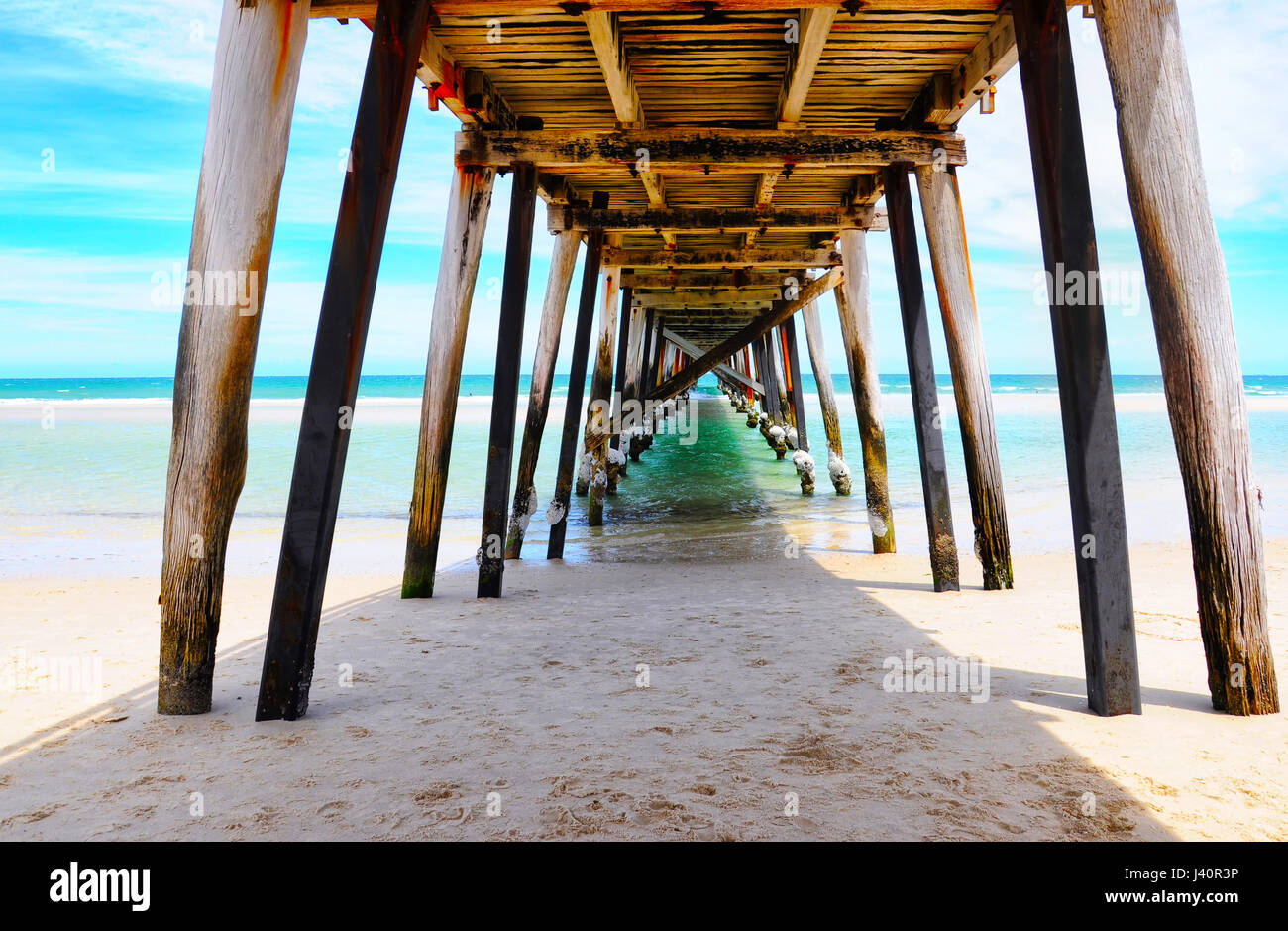 Underneath long jetty pier looking out across wide clean beautiful ...