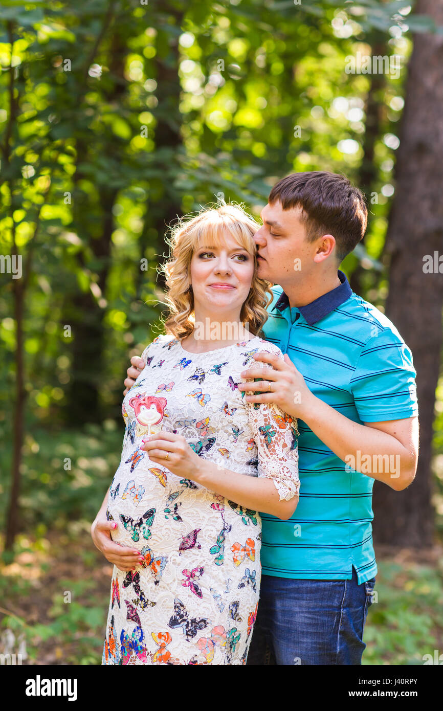 Happy young pregnant couple hugging in nature Stock Photo - Alamy