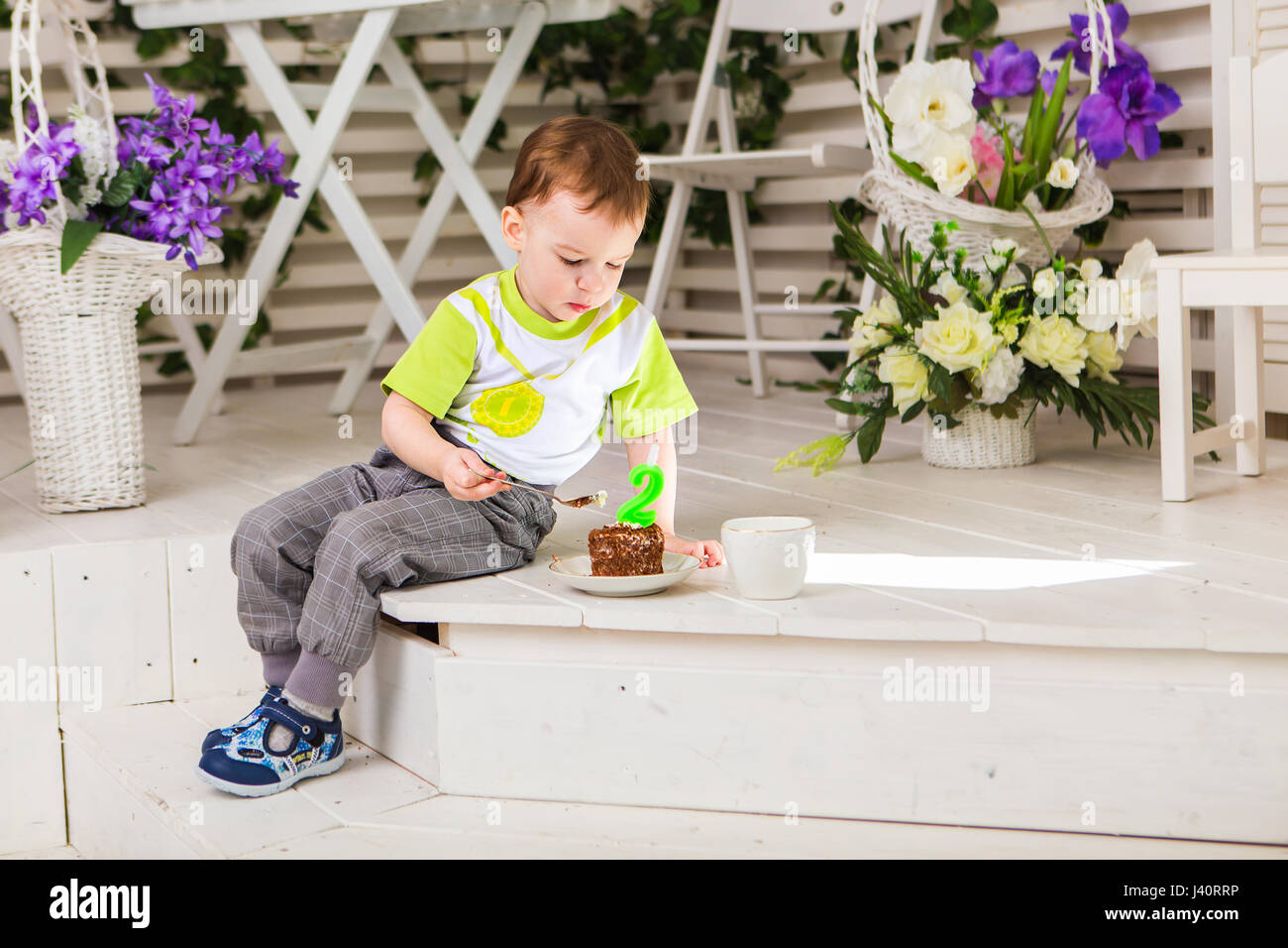Happy little kid boy celebrating his birthday holds piece of cake ...