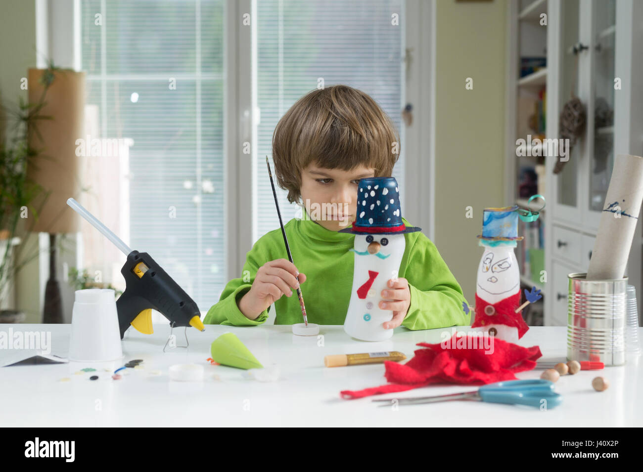 Little boy being creative making homemade do-it-yourself toys out of ...