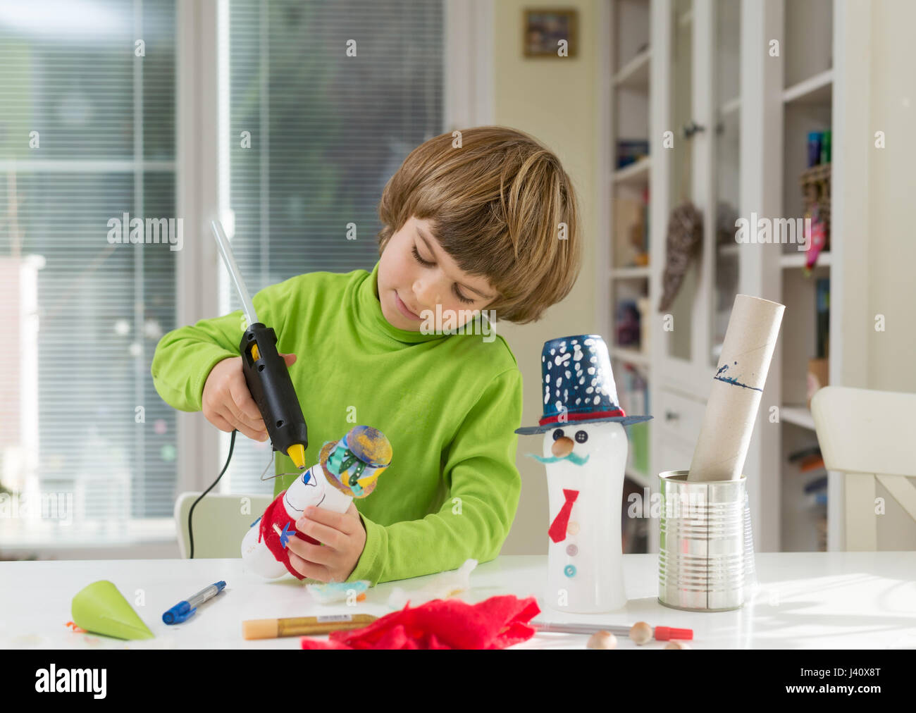 Little boy being creative making do-it-yourself toys out of yogurt ...