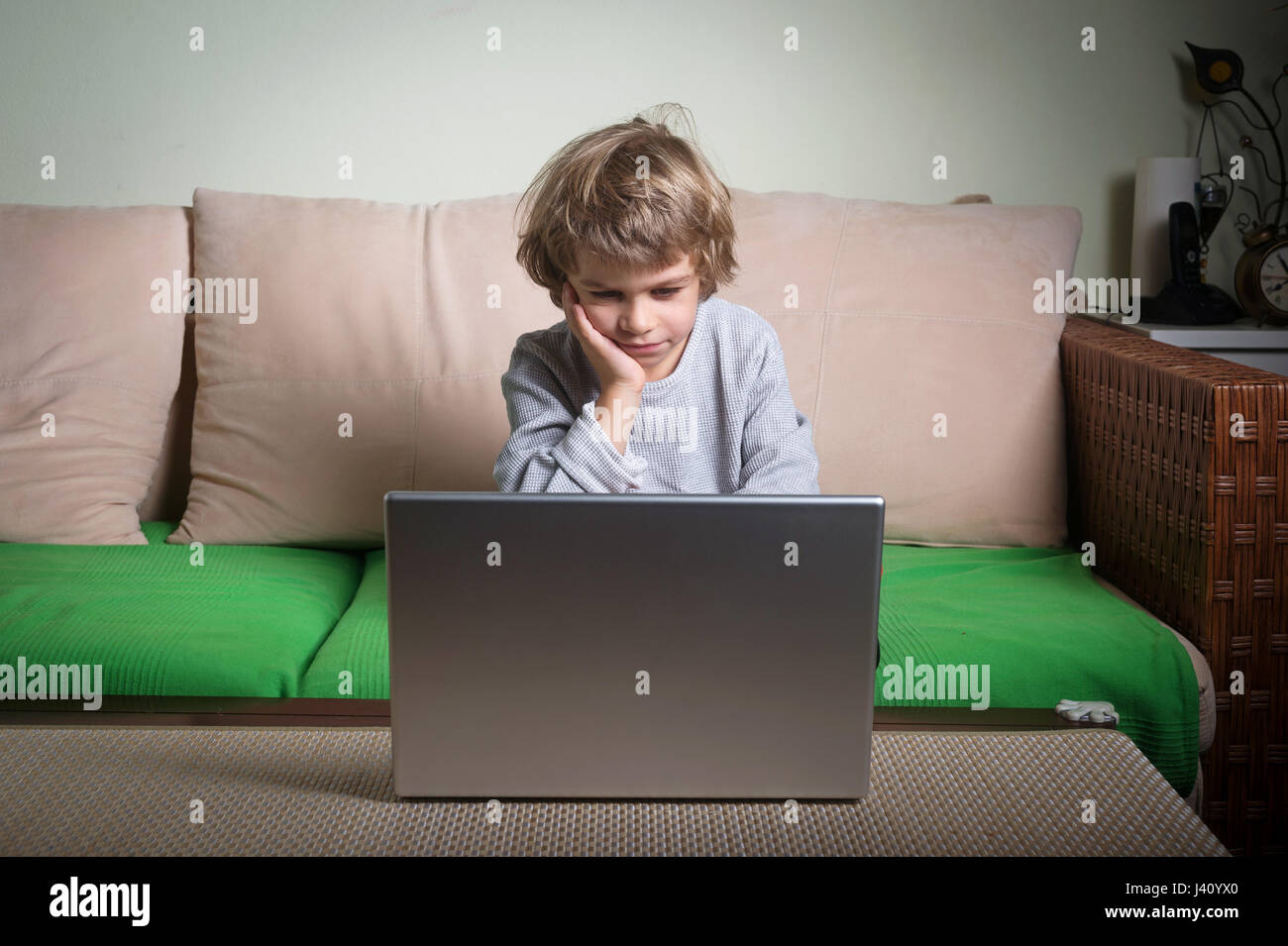 Little boy bored watching cartoons on computer Stock Photo - Alamy