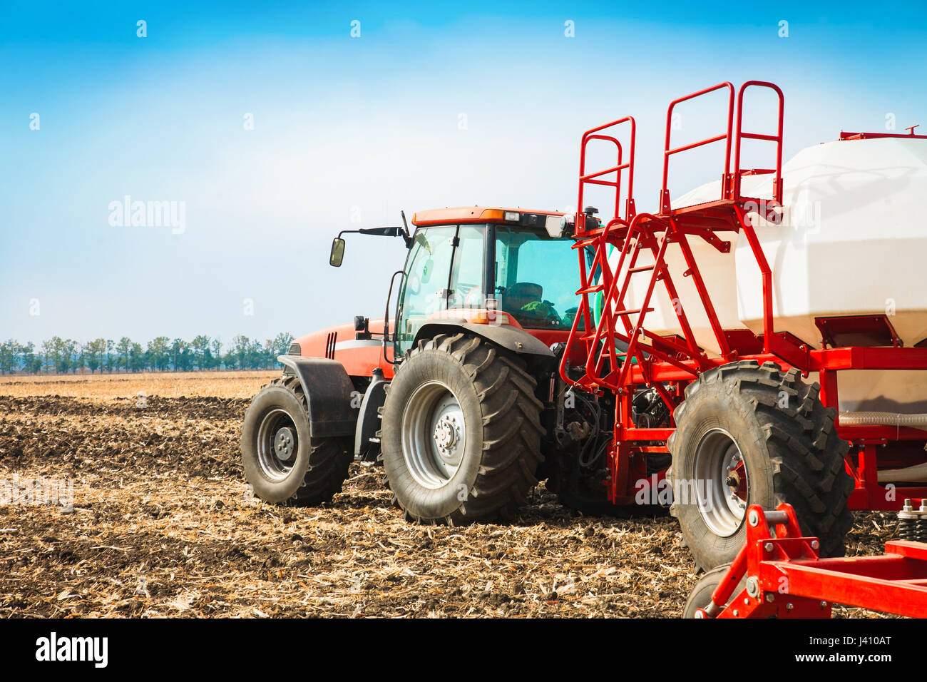 Tractor with tanks working in the field. Agricultural machinery and ...