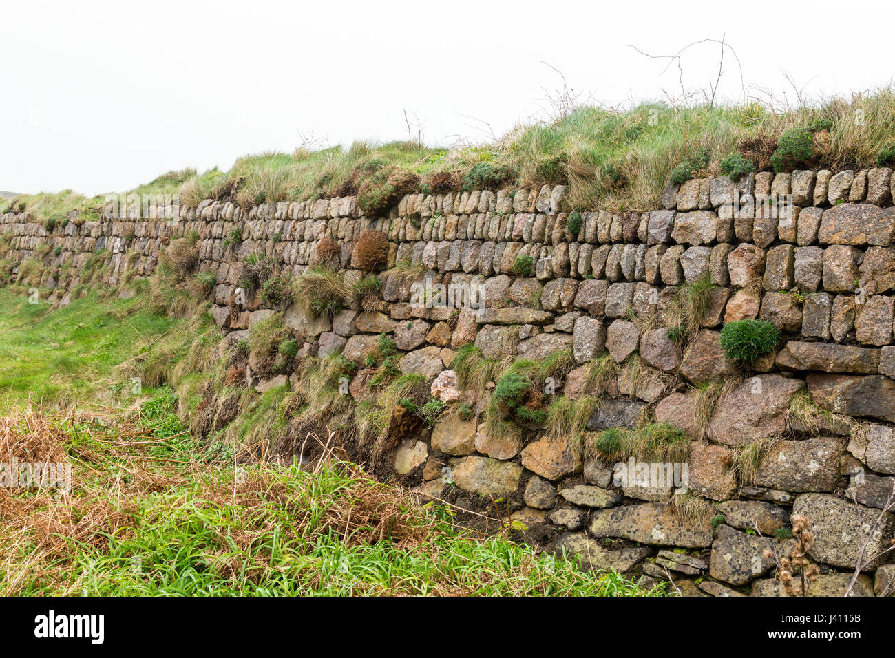 A dry stone wall built from granite blocks of different sizes and ...