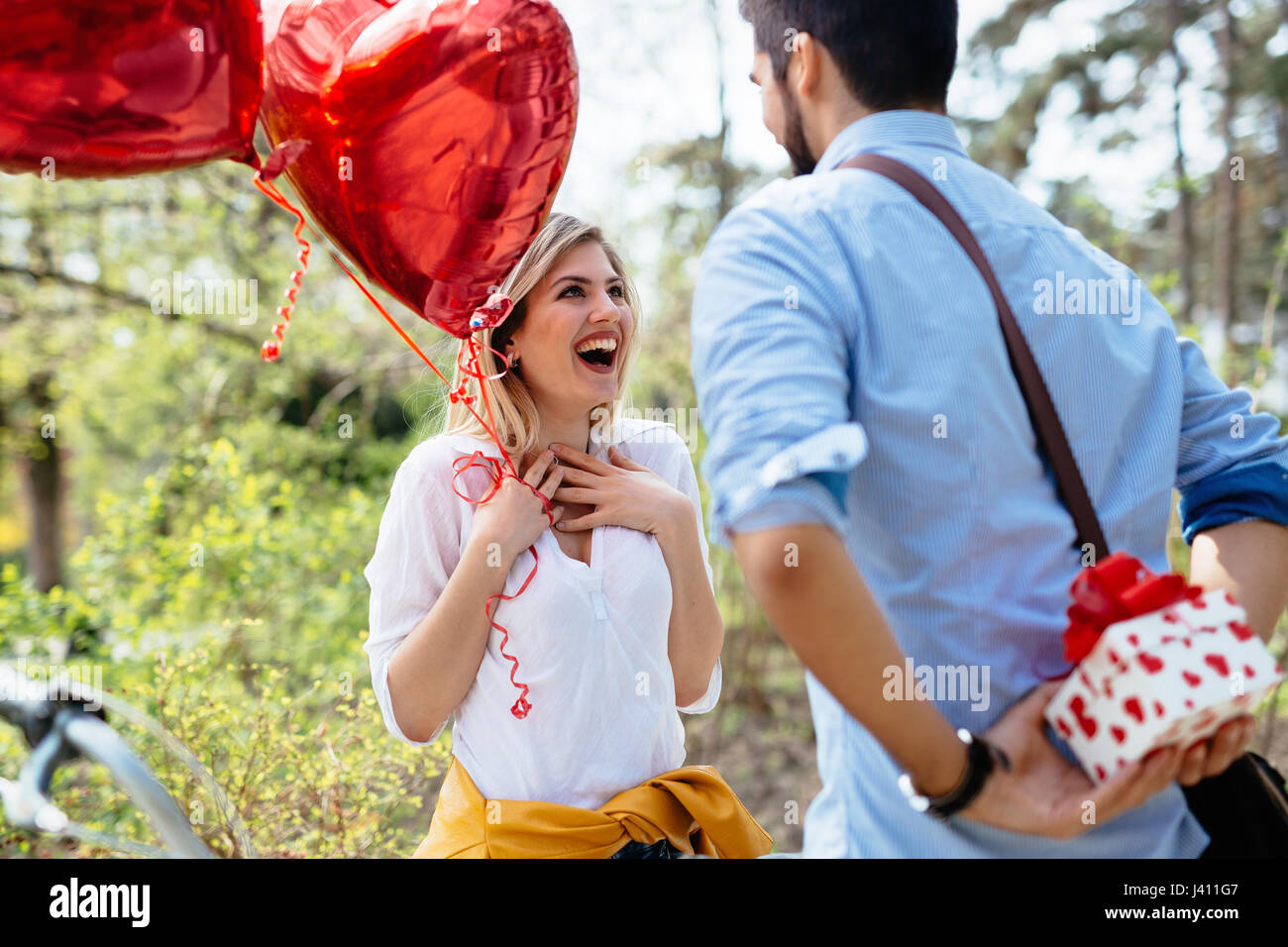 Man standing and holding white surprise gift box behind his back as ...