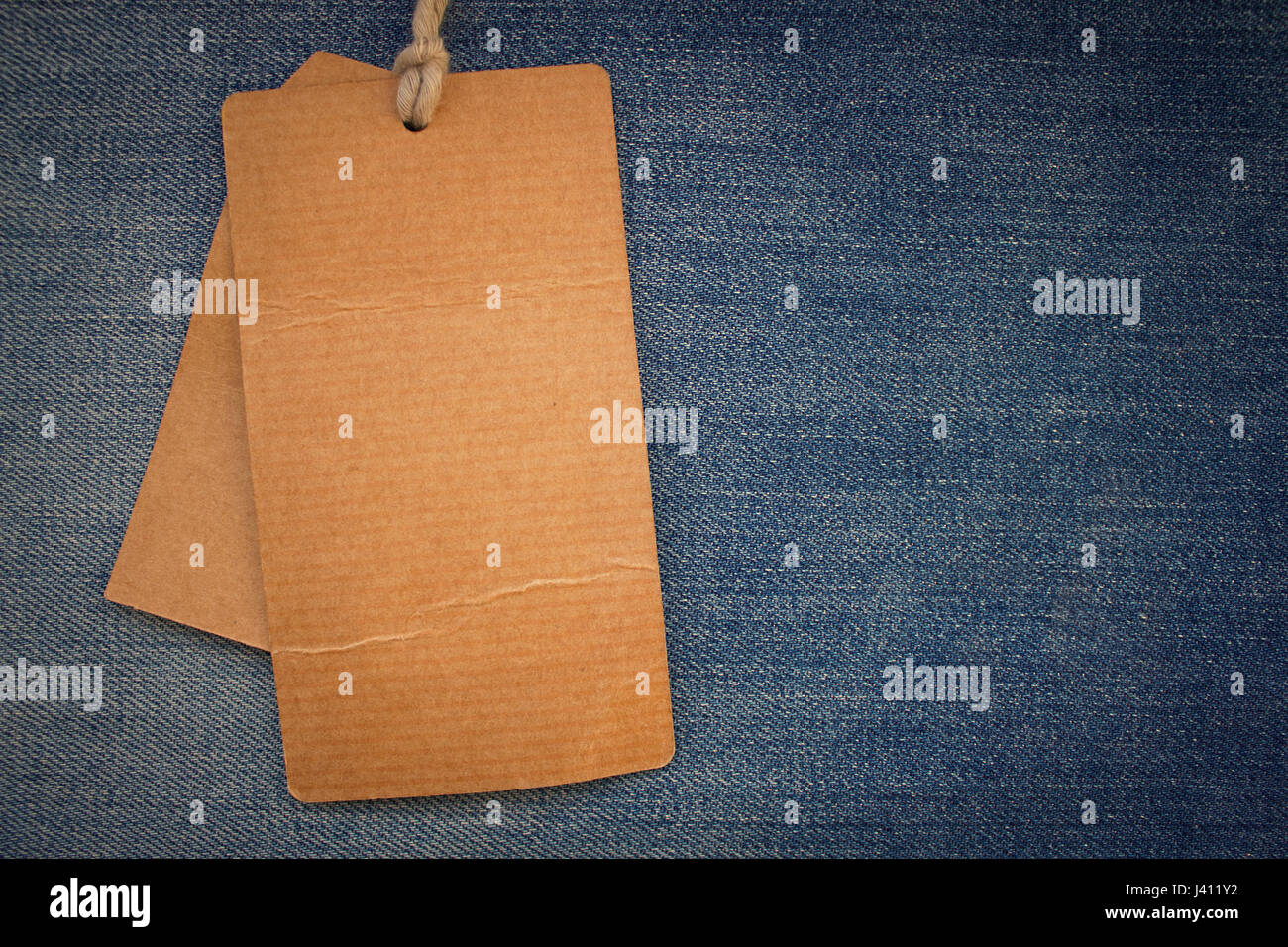 Two empty cardboard labels on a denim Stock Photo - Alamy