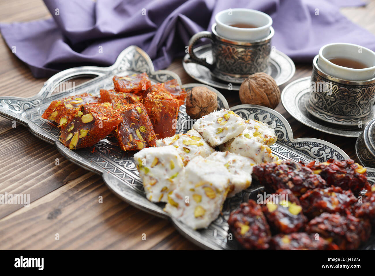 Turkish delight with tea and metal oriental tray on wooden background ...