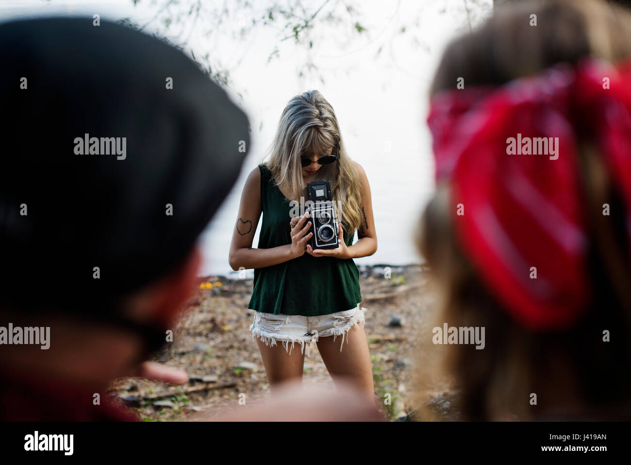 Woman Taking Friends Photo by Retro Camera on Road Trip Stock Photo - Alamy