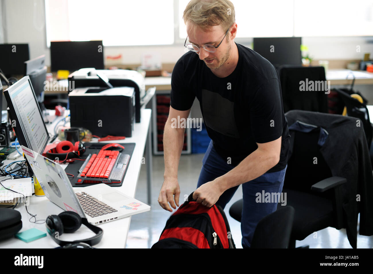 Man Grabbing Backpack Leaving After Work Hour Stock Photo - Alamy
