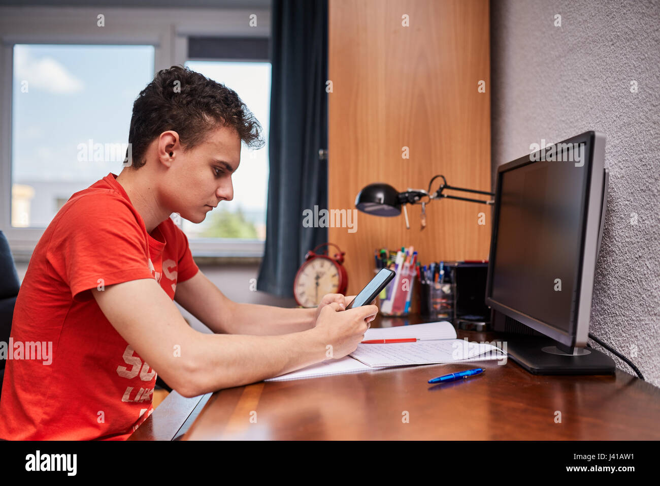 Teenager boy doing homework on his desk at home Stock Photo - Alamy
