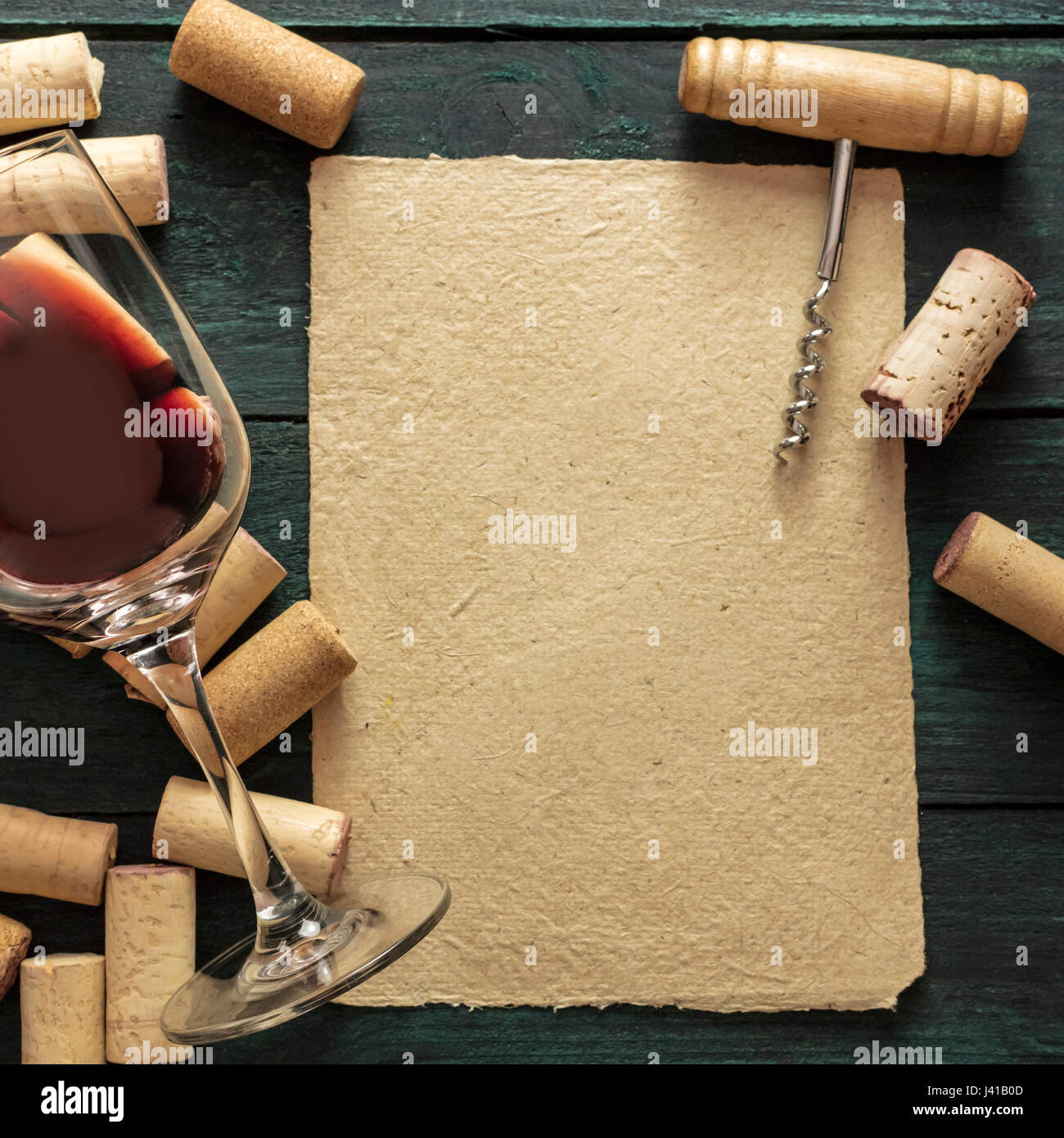 A piece of old parchment paper with a frame of corks, a glass of red ...