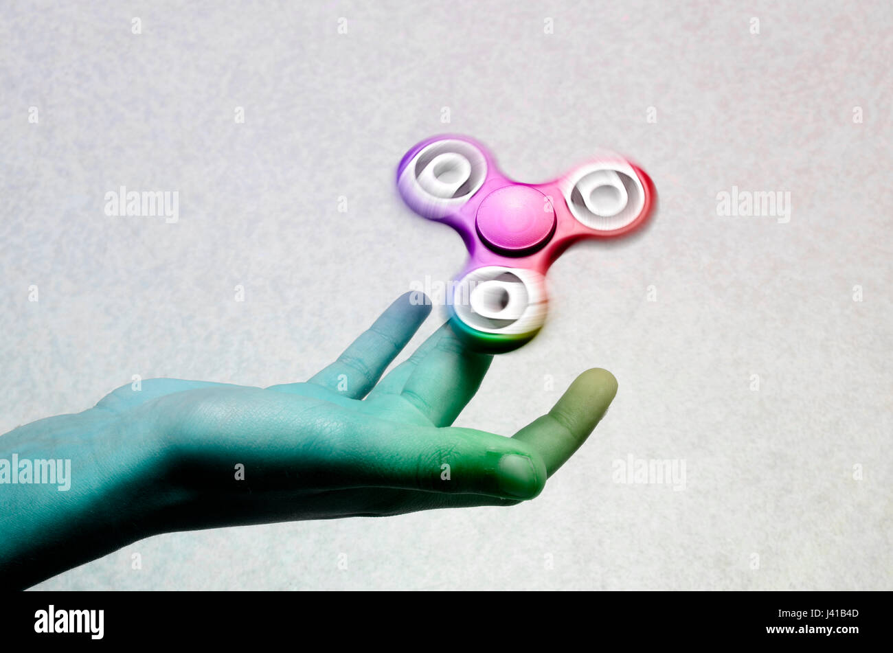 Blue Hand spinner, fidgeting hand toy rotating on child's finger Stock ...