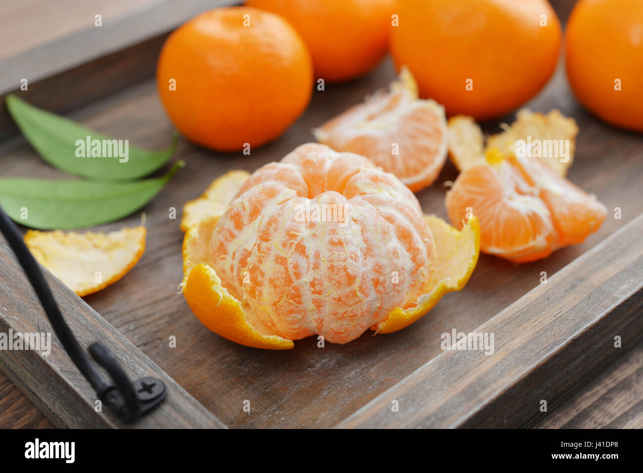 Tangerines on tray over wooden background closeup Stock Photo - Alamy
