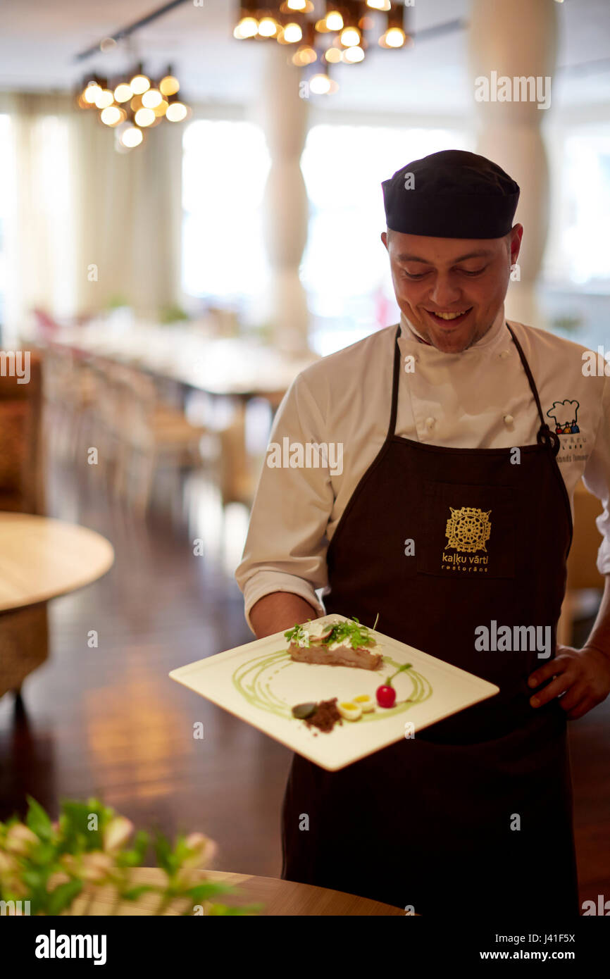 Chef Raimonds Zommers with main dish, raw salted Zander, modern ...