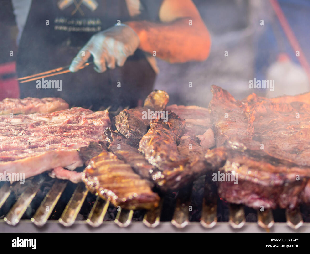 Grilling red meat and sausages at sunset outdoors gathering with ...