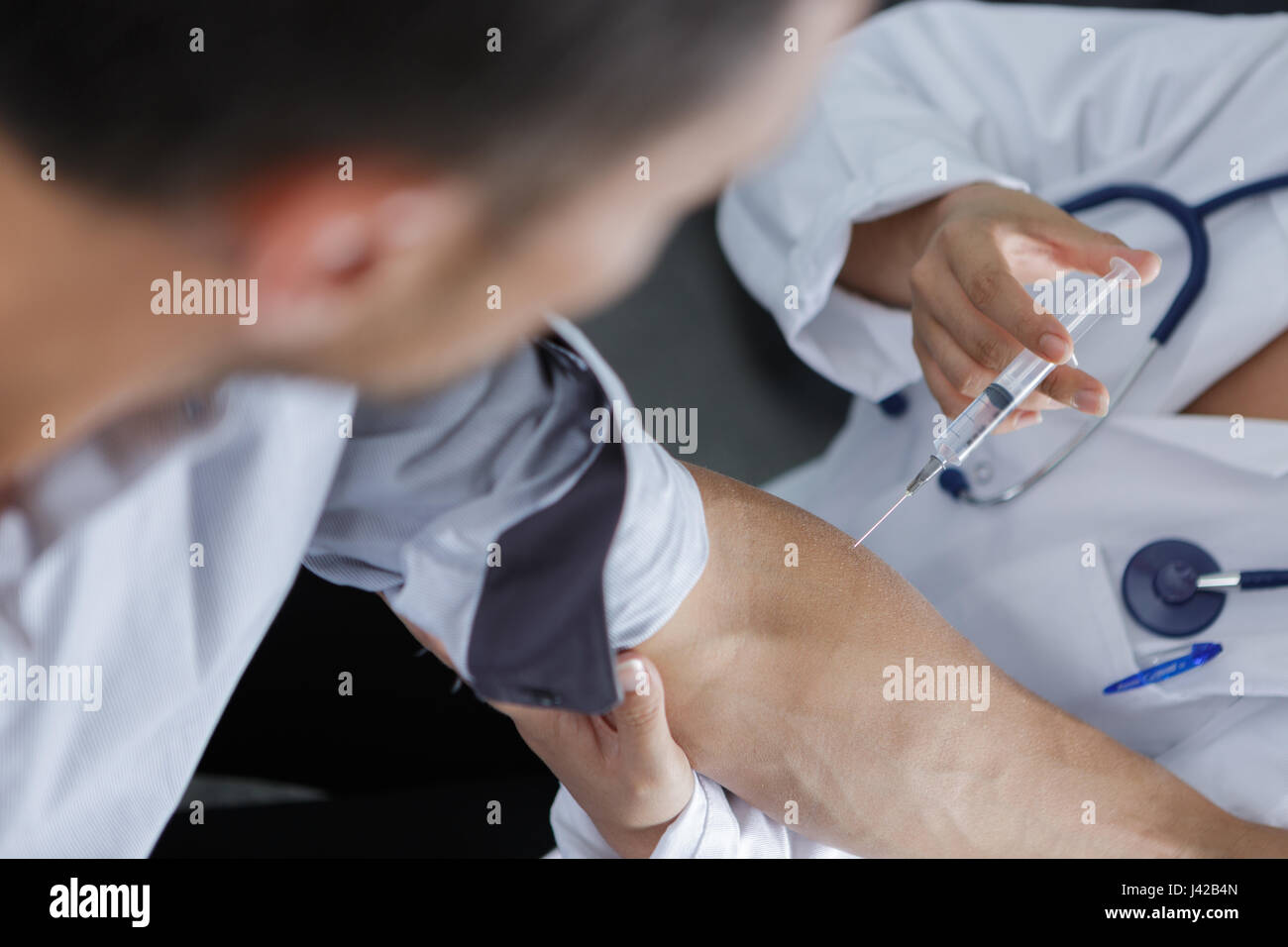 doctor injection flu vaccine to patients arm Stock Photo - Alamy