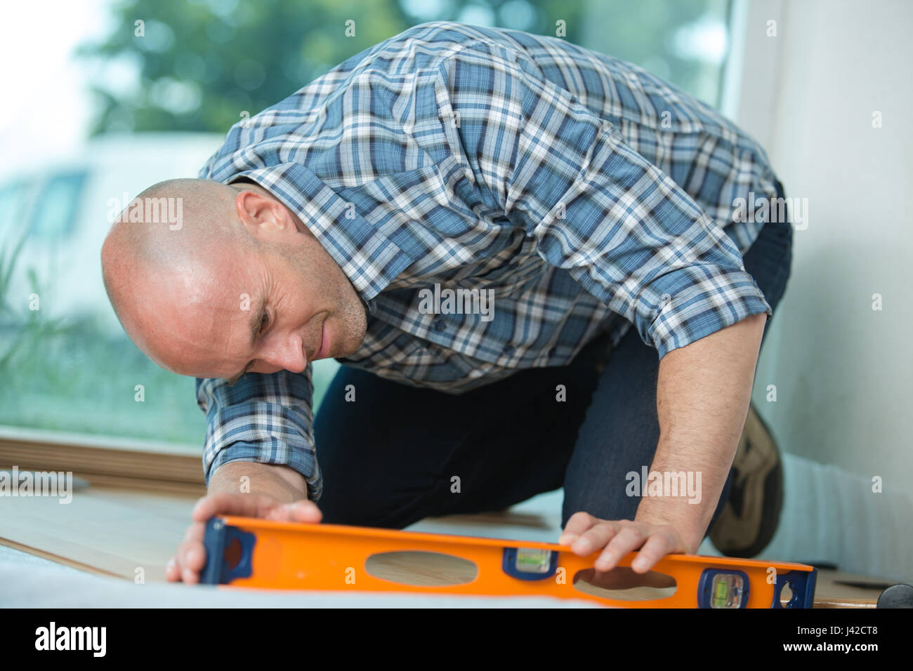Man checking flooring is level Stock Photo - Alamy