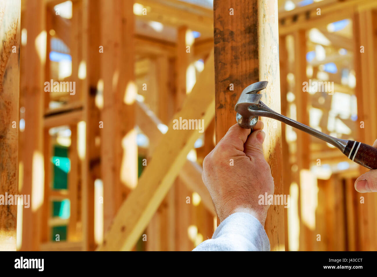 builder worker nailing with hammer at wall construction works Stock ...