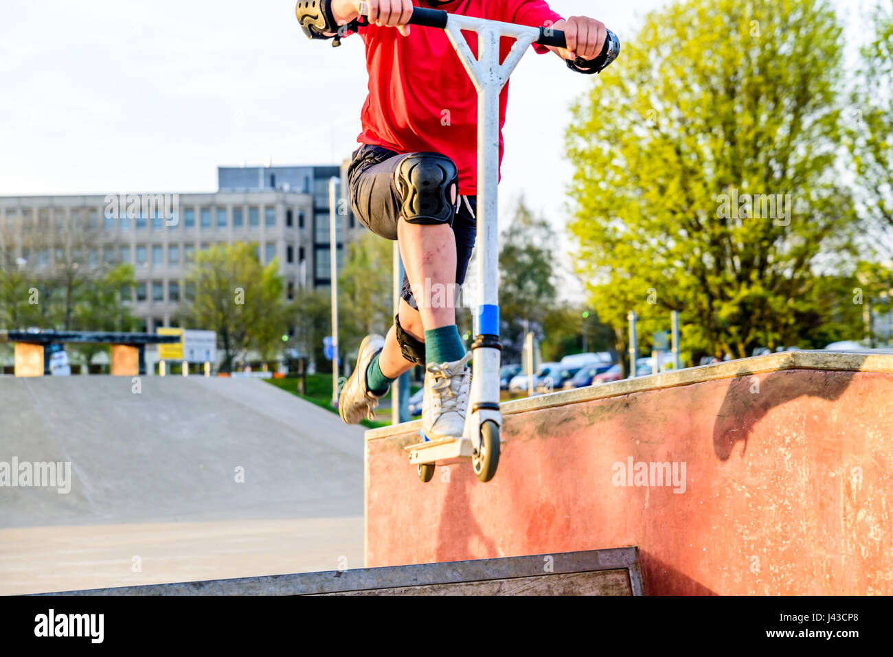 Day view teen boy riding scooter on skating playground Stock Photo - Alamy