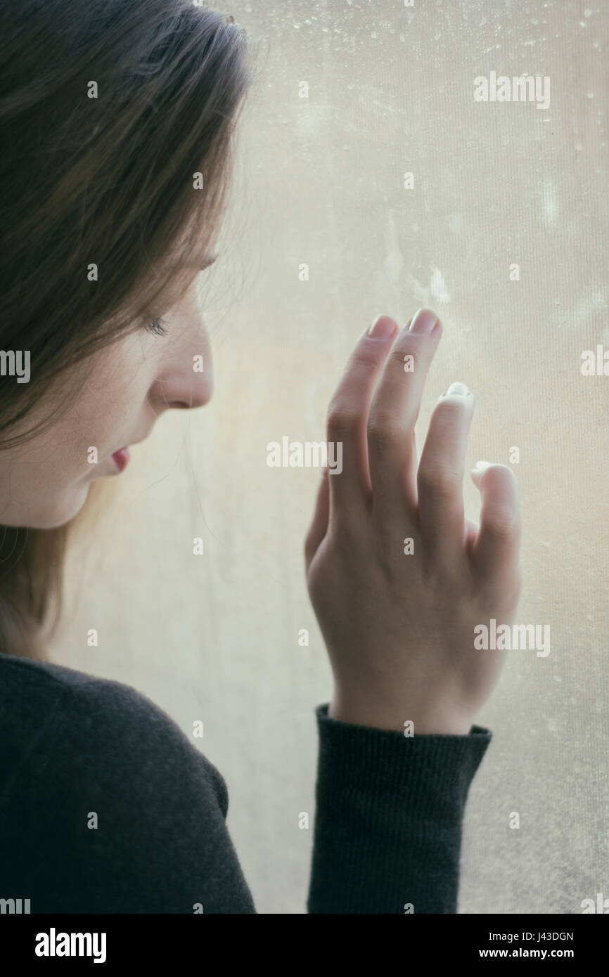 Sad young woman hand touching the window Stock Photo - Alamy