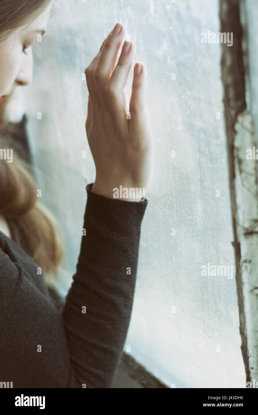 Sad young woman hand touching the window Stock Photo - Alamy
