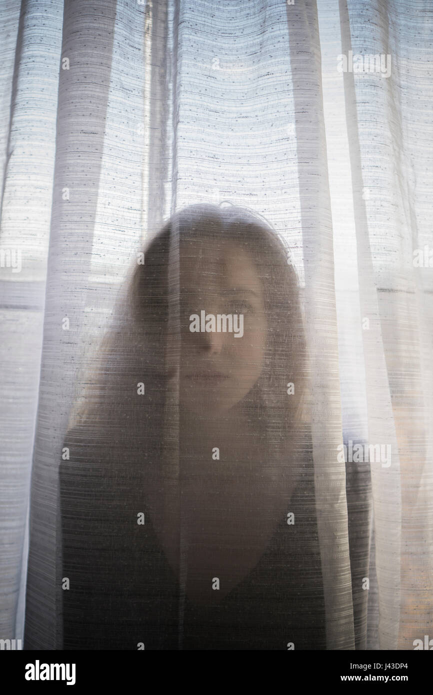 Woman looking through window blinds hi-res stock photography and images ...