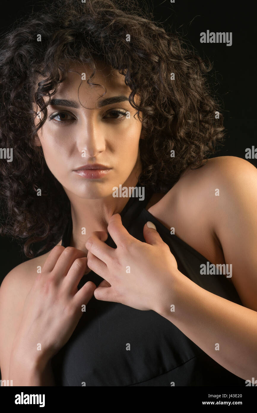 Beautiful young woman hands over chest staring Stock Photo - Alamy