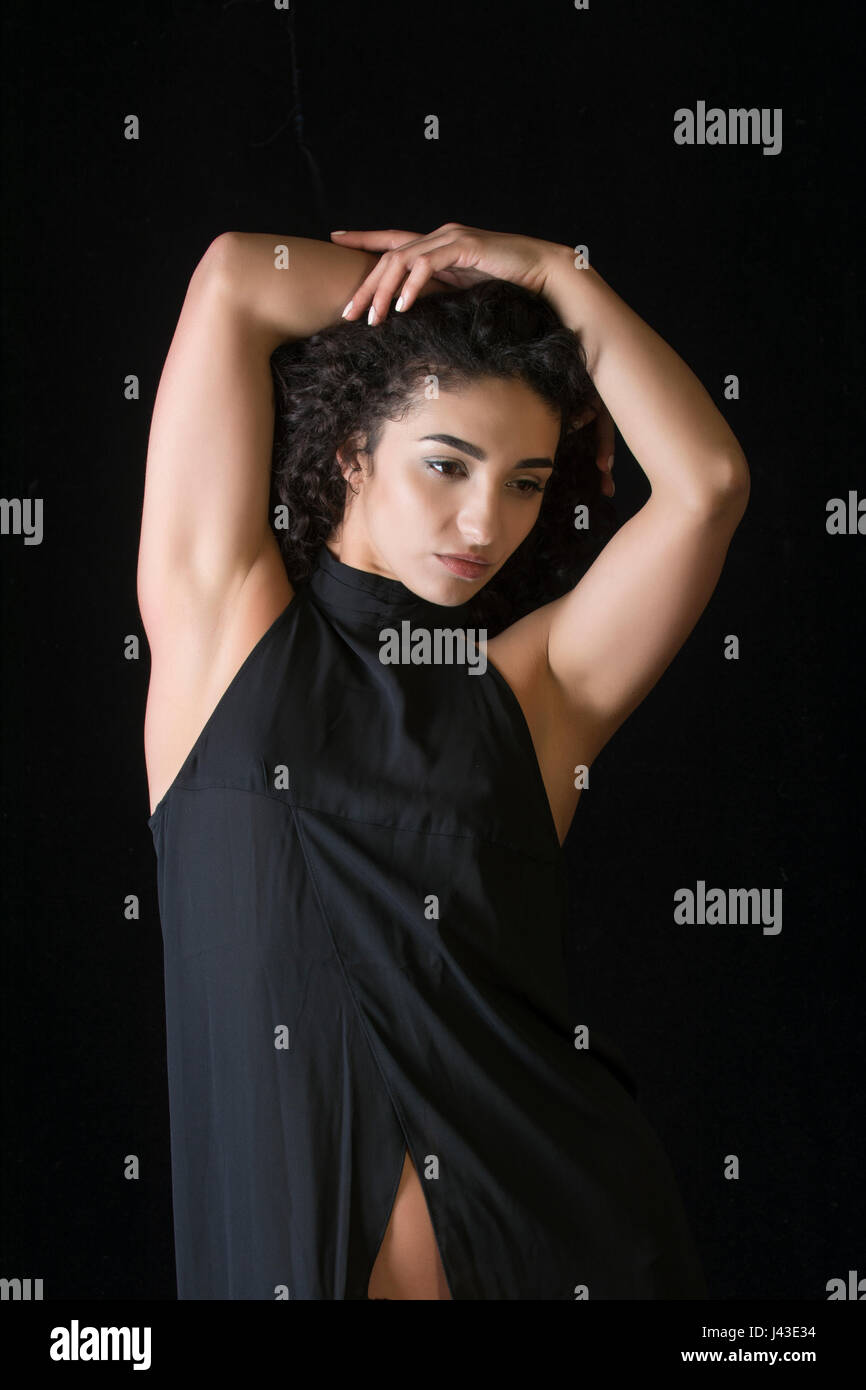 Beautiful young woman hands over head looking away Stock Photo - Alamy