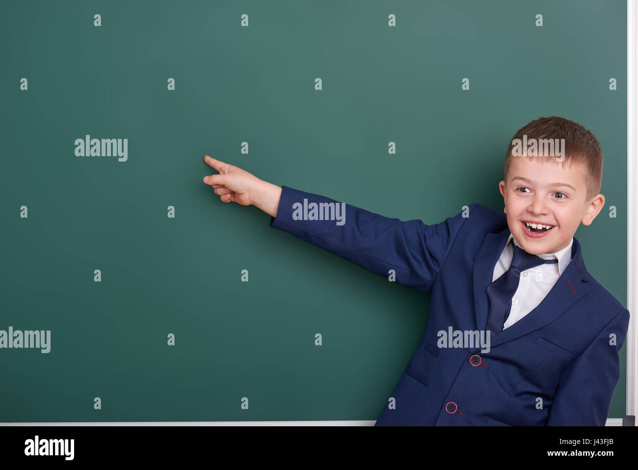 school boy point the finger near blank chalkboard background, dressed ...