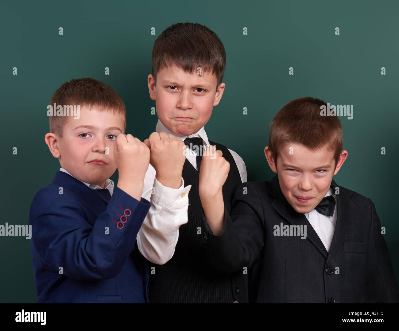 group pupil as a gang, show knuckle, posing near blank chalkboard ...