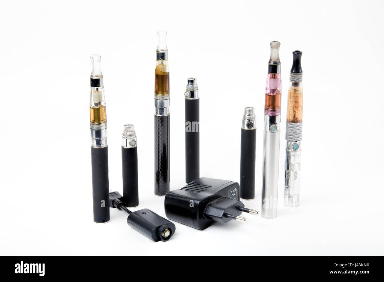 Thin e-cigarettes with charger and smoke on white background Stock ...