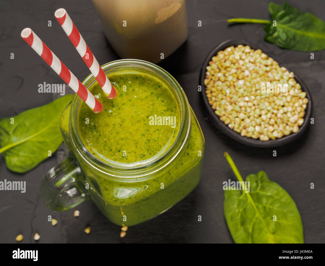 Top view of green smoothie in mason jar on black concrete background ...