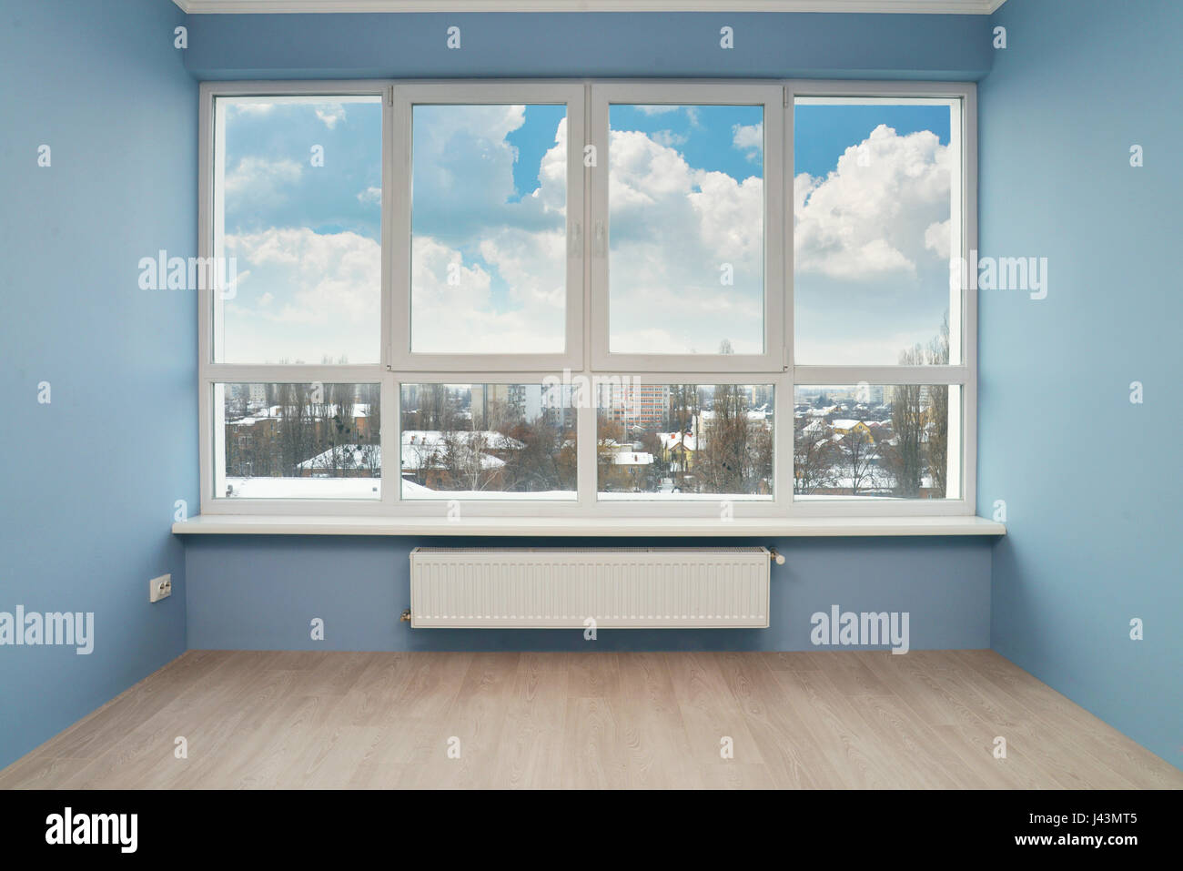 Empty room with large window and blue walls Stock Photo - Alamy