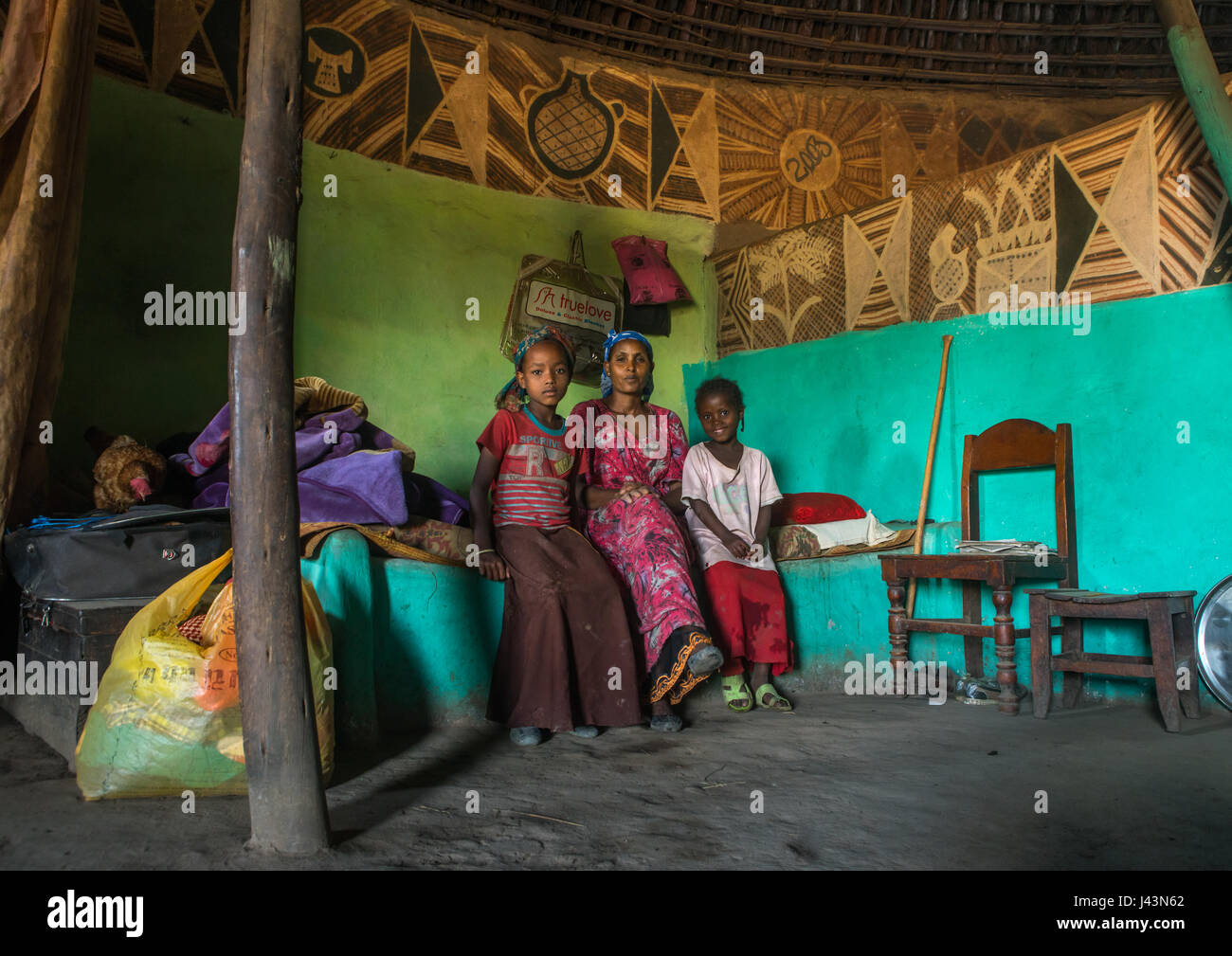 Ethiopian woman with her children inside her traditional painted and ...