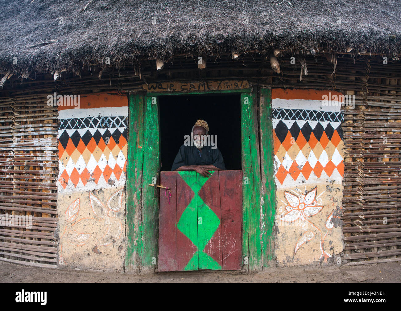 Ethiopian muslim man standing in front of his traditional painted house ...