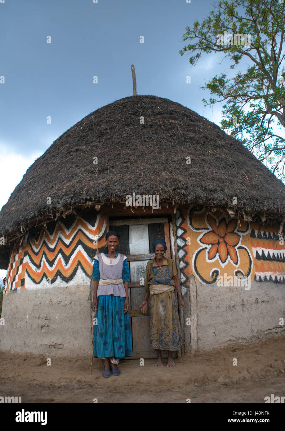 Women standing in front of their traditional painted house, Kembata ...