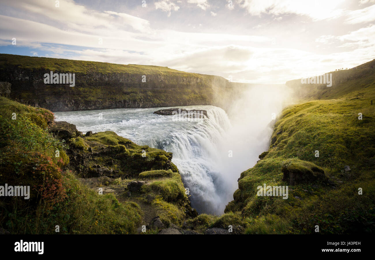 Cold water in Iceland. Waterfall in rocky mountains. Fresh and green ...