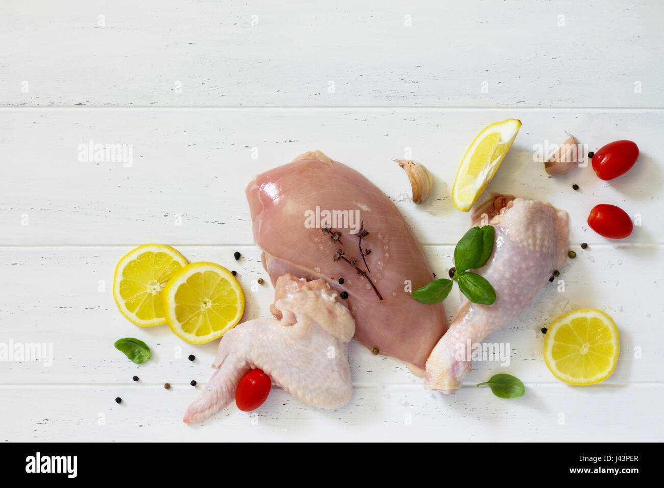 Fresh chicken meat raw fillet, wing, thigh and shank with lemon, spices ...