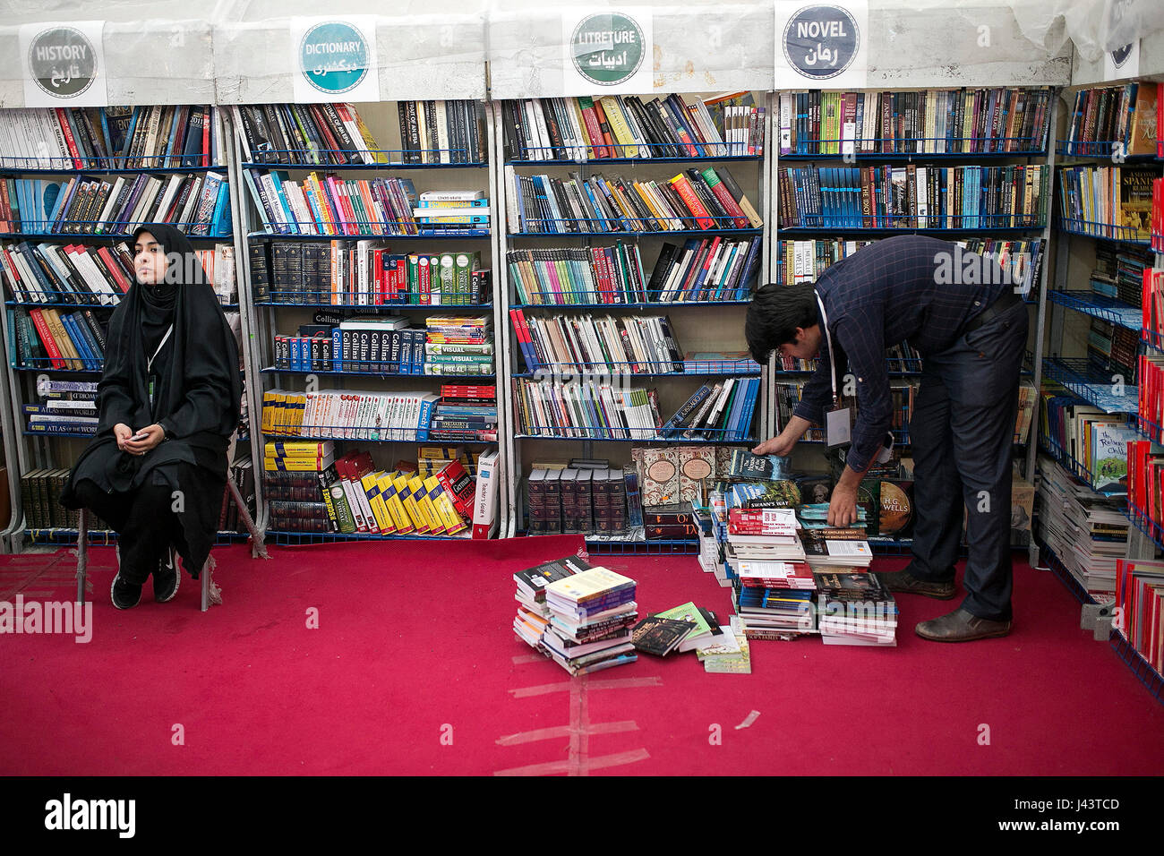 Tehran, Iran. 8th May, 2017. A staff member arranges books at the 30th ...