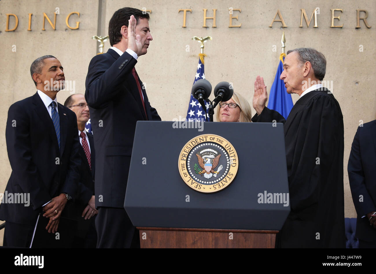 FBI Director James Comey (3rd L) participates in a ceremonial swearing ...