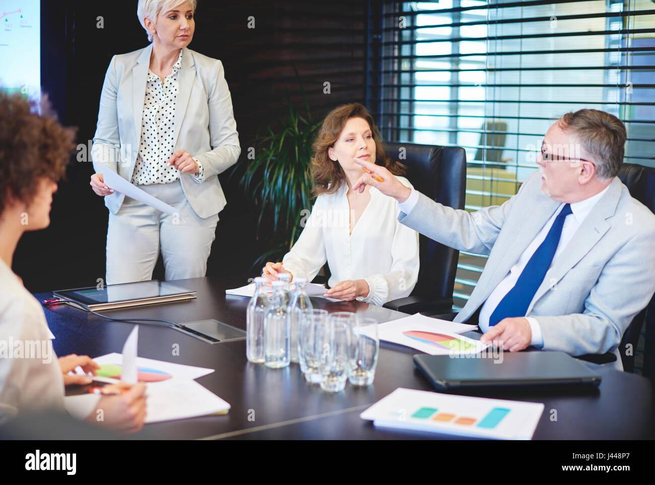 Business people comparing statistics together Stock Photo - Alamy