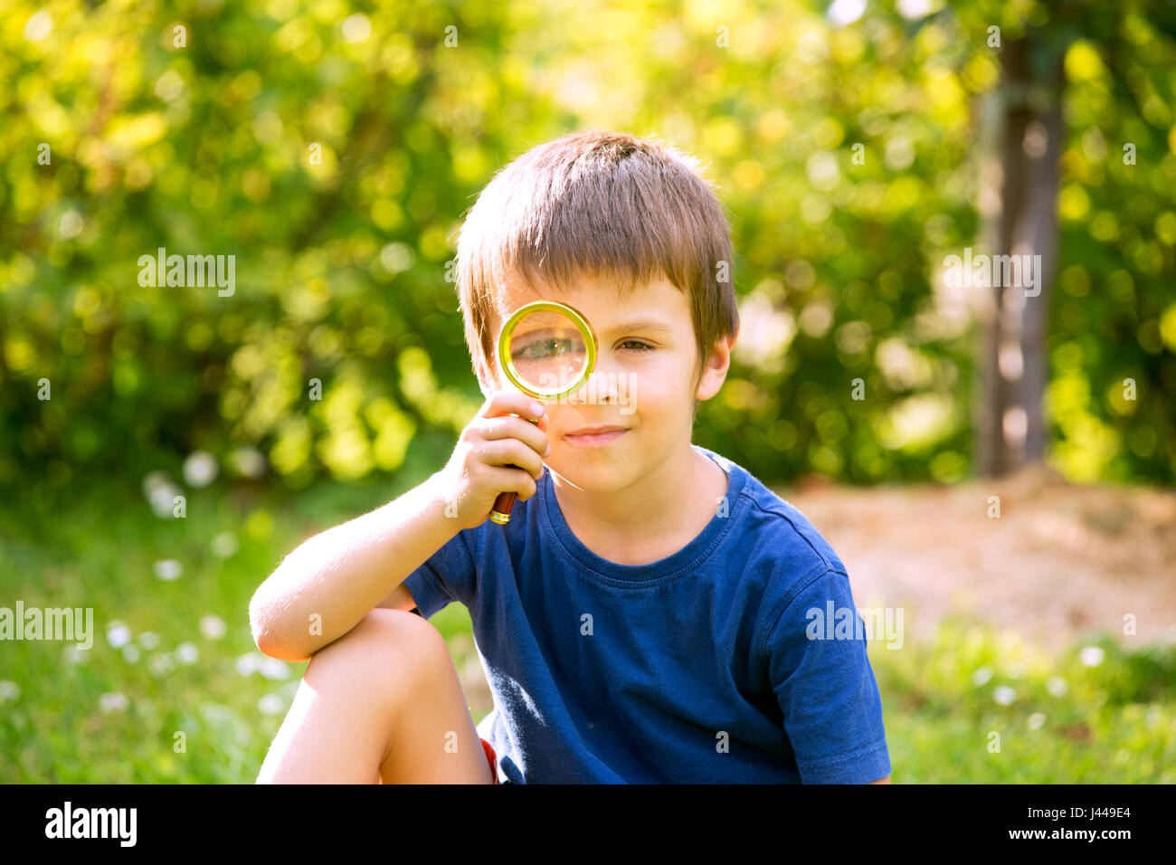 Beautiful happy child, boy, exploring nature with magnifying glass, summertime Stock Photo - Alamy