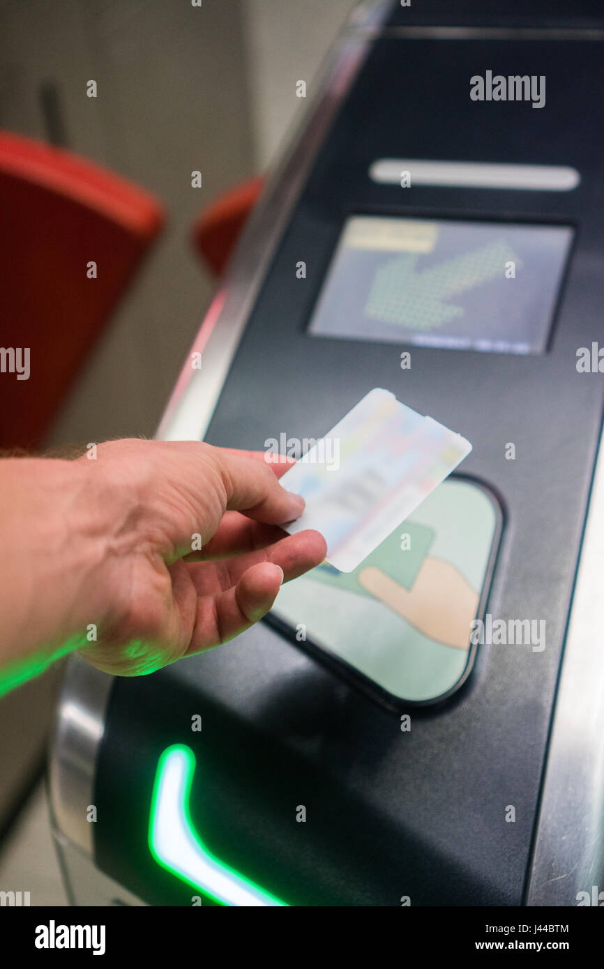 Closeup of man's hand scanning ticket at the metro station entrance ...