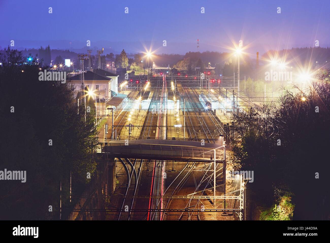 Red tail lights of the express train in railway station at night ...