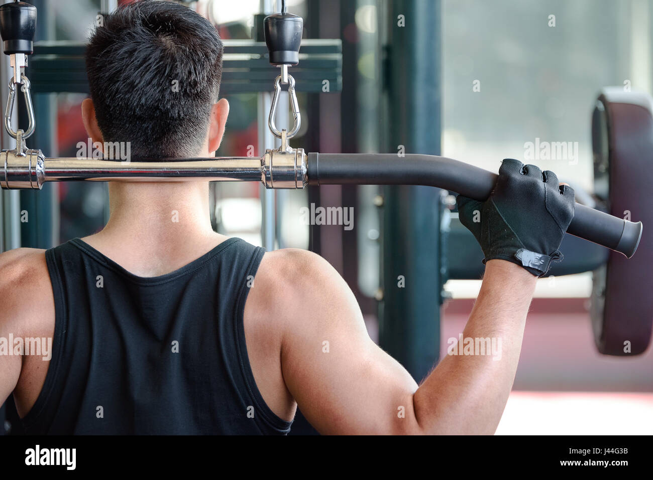 Asia Man's back with muscle in lat pull-down gym machine. Tough guy so ...