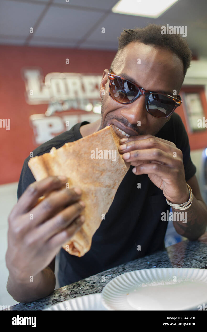 A young man eating pizza Stock Photo - Alamy