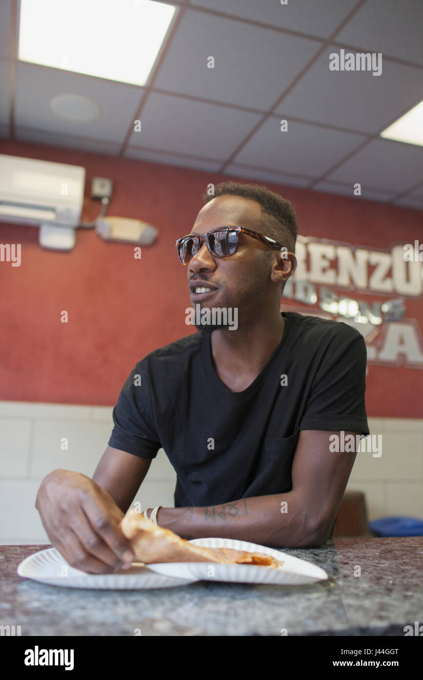 A young man eating pizza Stock Photo - Alamy
