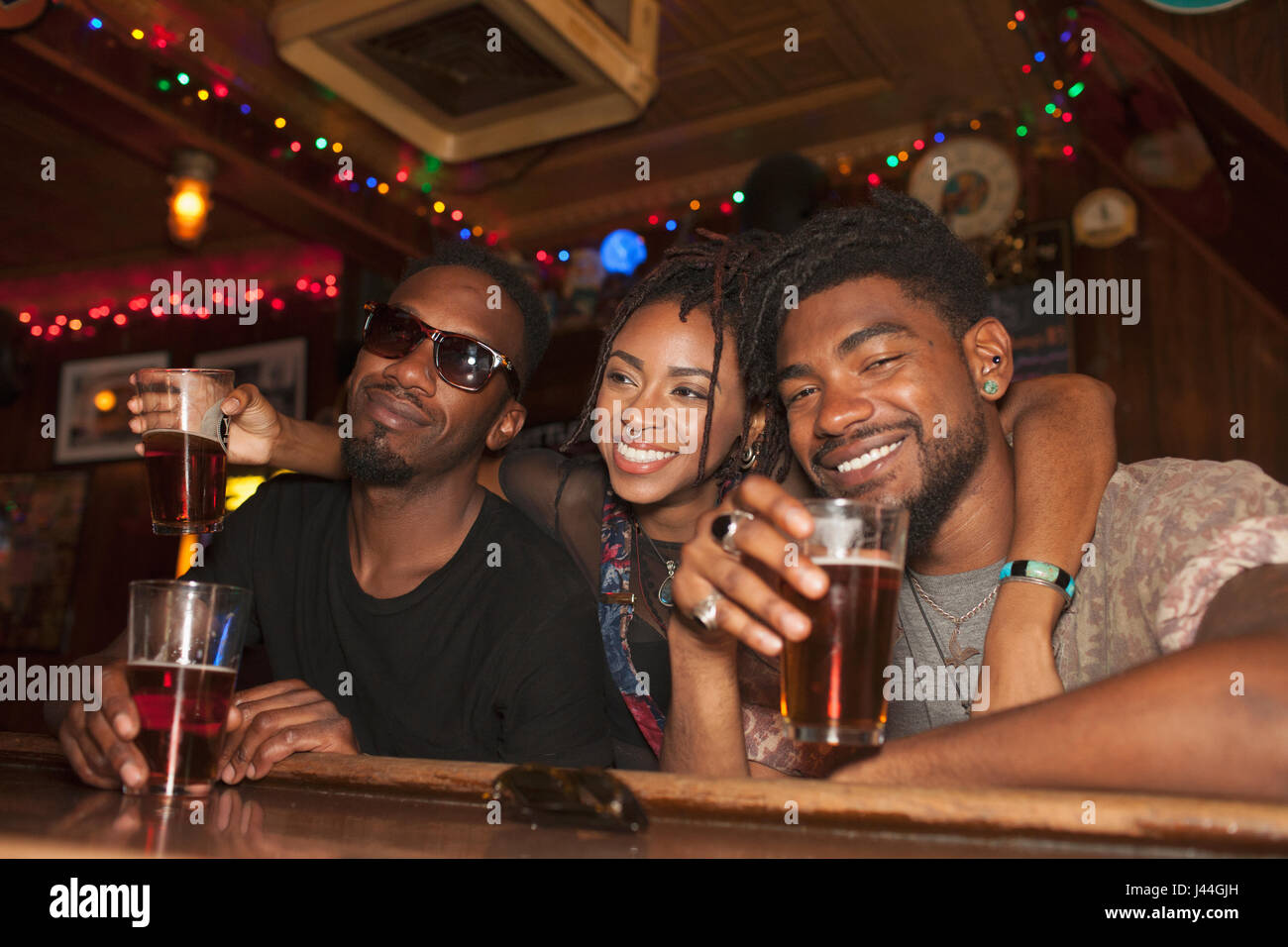 Three young friends at a bar Stock Photo - Alamy