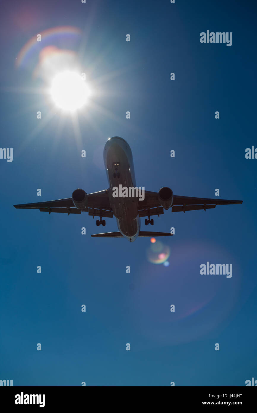 Jet liner landing at Toronto Pearson Airport with sun in the background ...