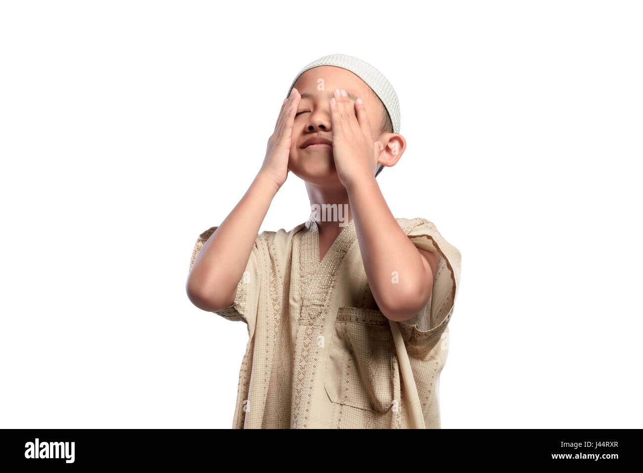 Little asian muslim kid with white cap praying isolated over white ...